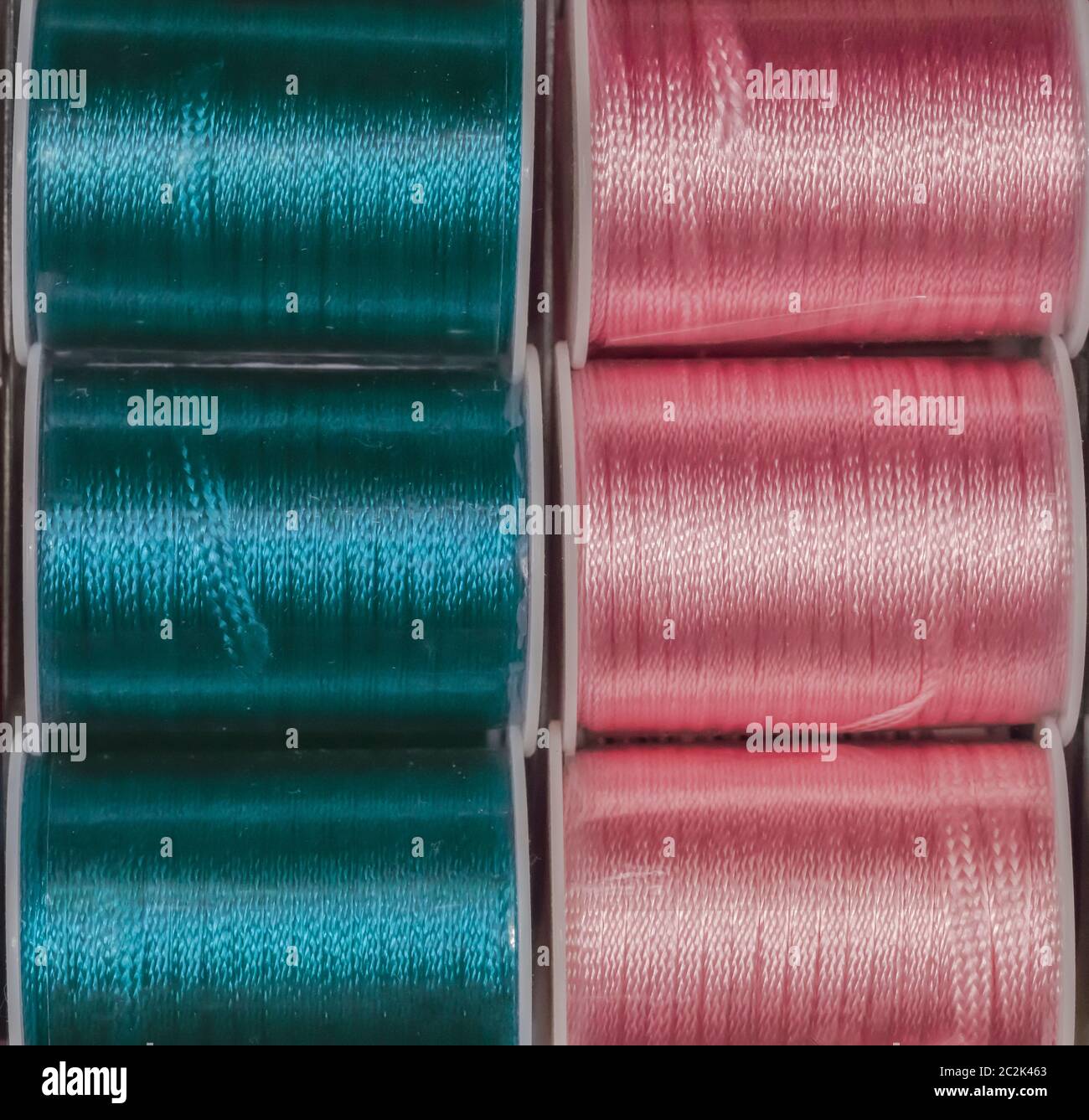 Cutout texture closeup on coils of colored sewing threads blue and pink ...