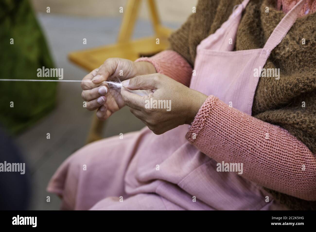 Spinning with a wooden spinning wheel, handicraft detail, thread ...