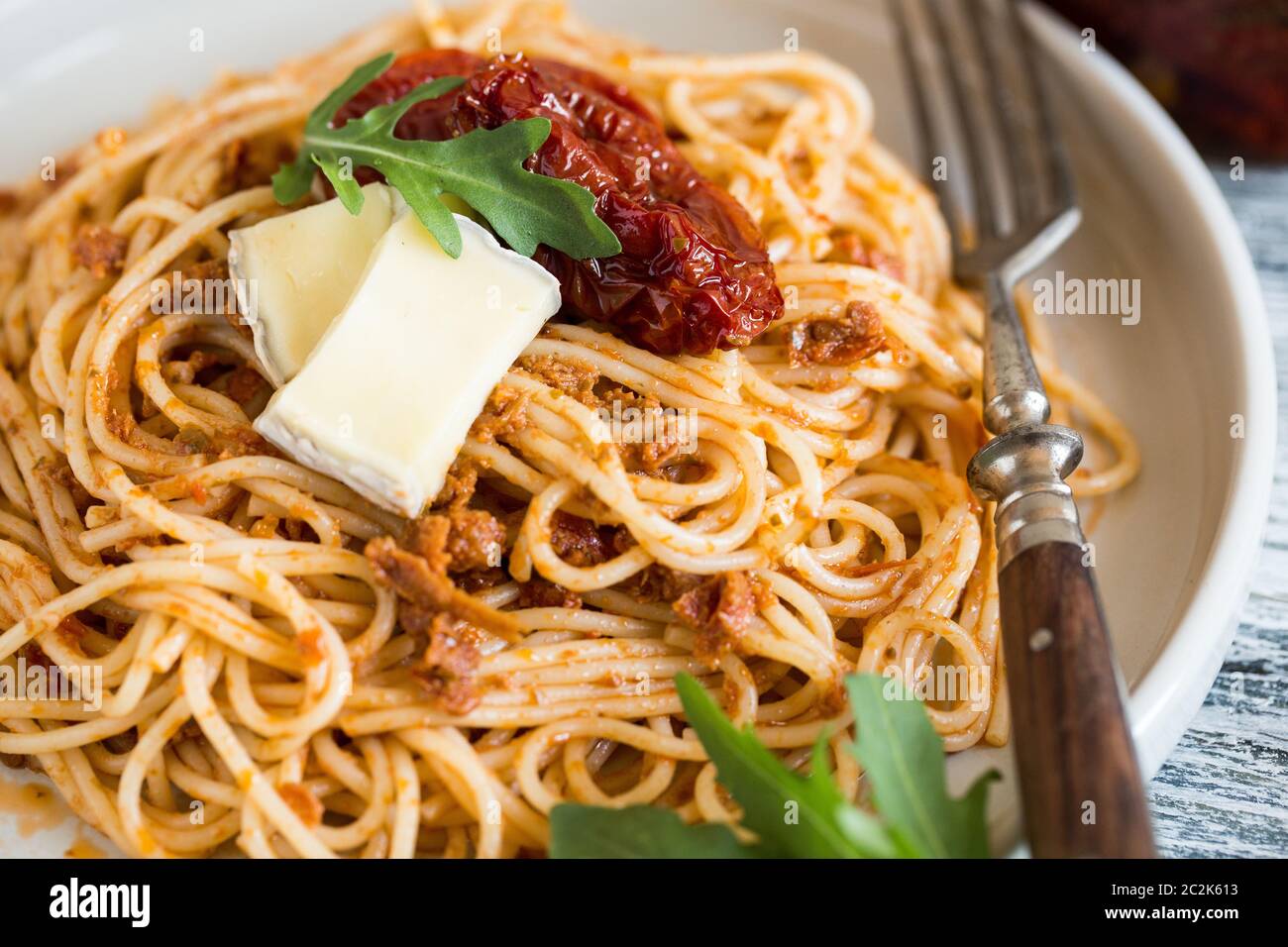 Italian Pasta with sun-dried tomato pesto and brie cheese Stock Photo ...