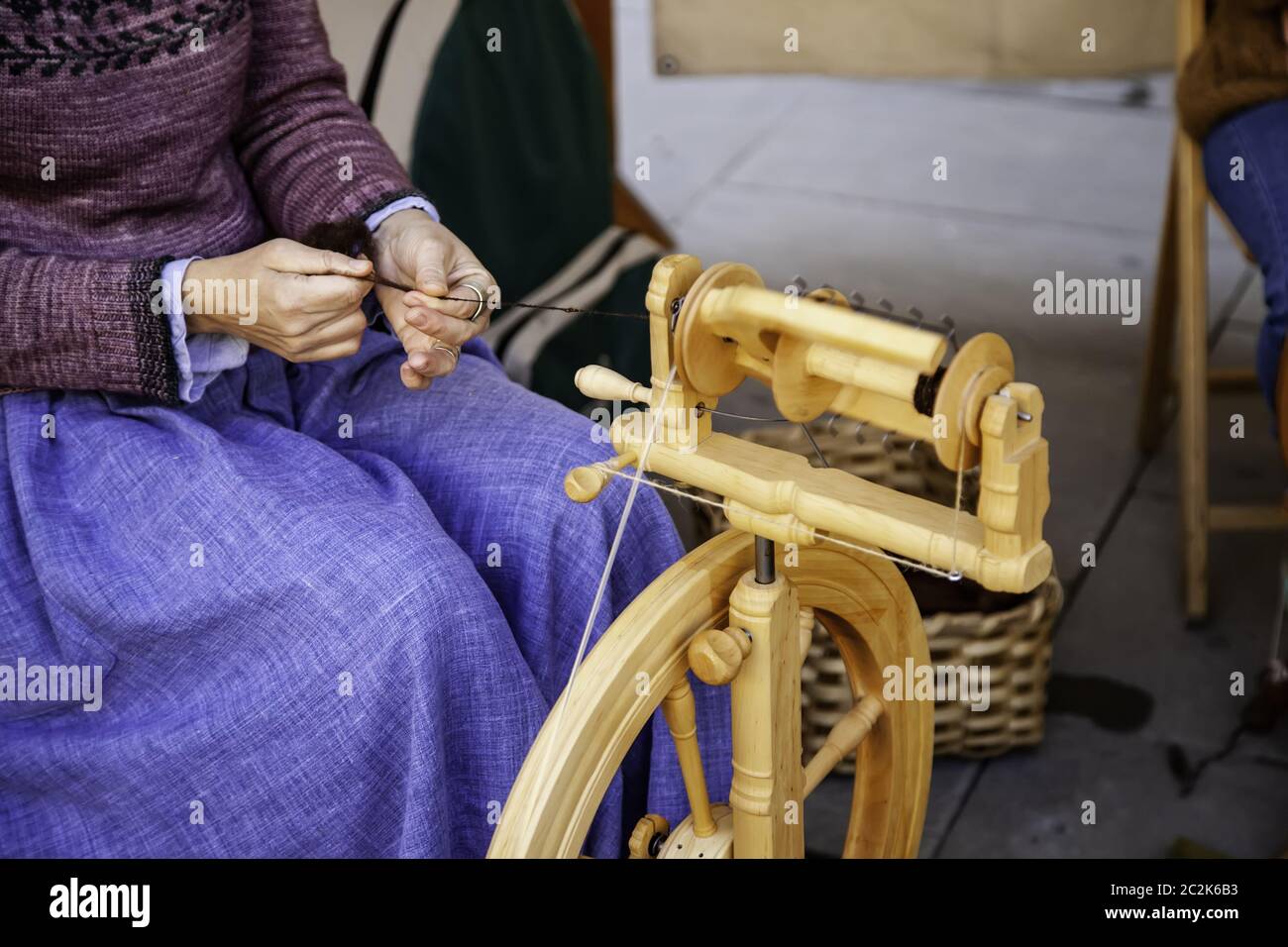 Spinning with a wooden spinning wheel, handicraft detail, thread ...