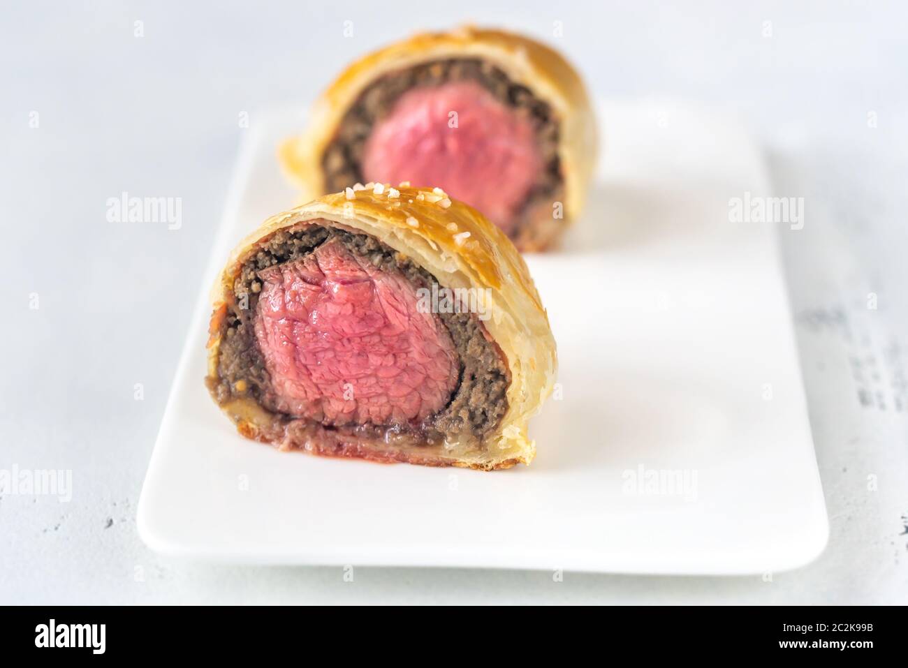 Portion of beef Wellington on the white plate: cross section Stock ...