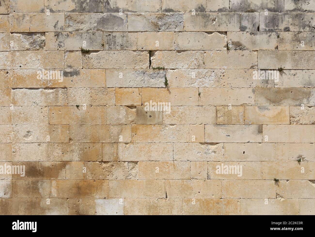 Wall of white and gray adarce travertine stone brick blocks, close up ...