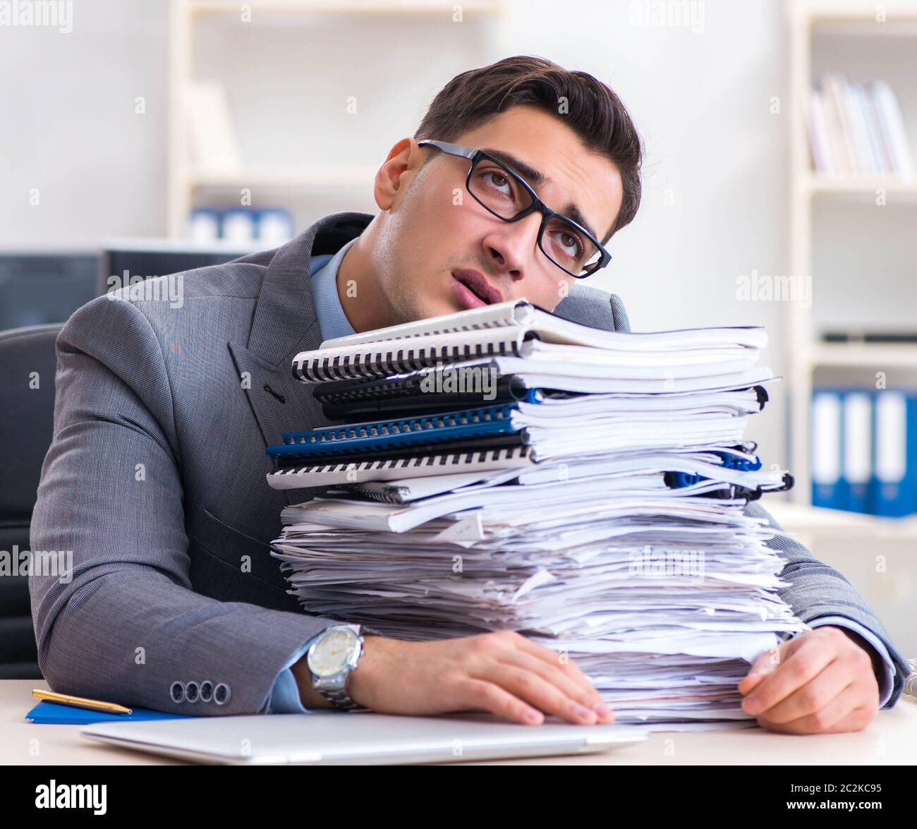 The overloaded with work employee under paperwork burden Stock Photo ...