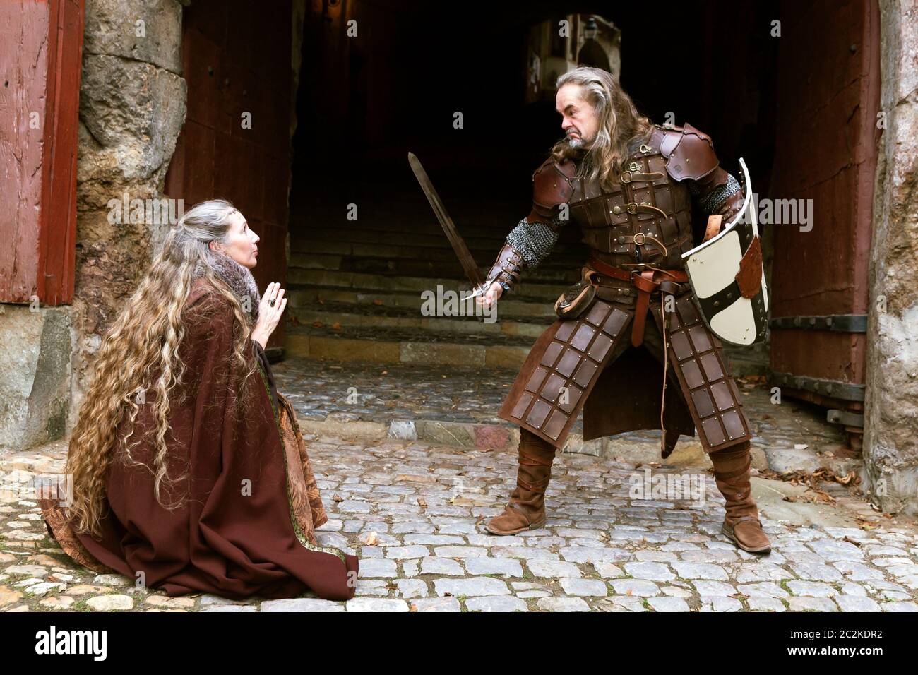 Aggressive Knight threatens woman with his sword Stock Photo - Alamy