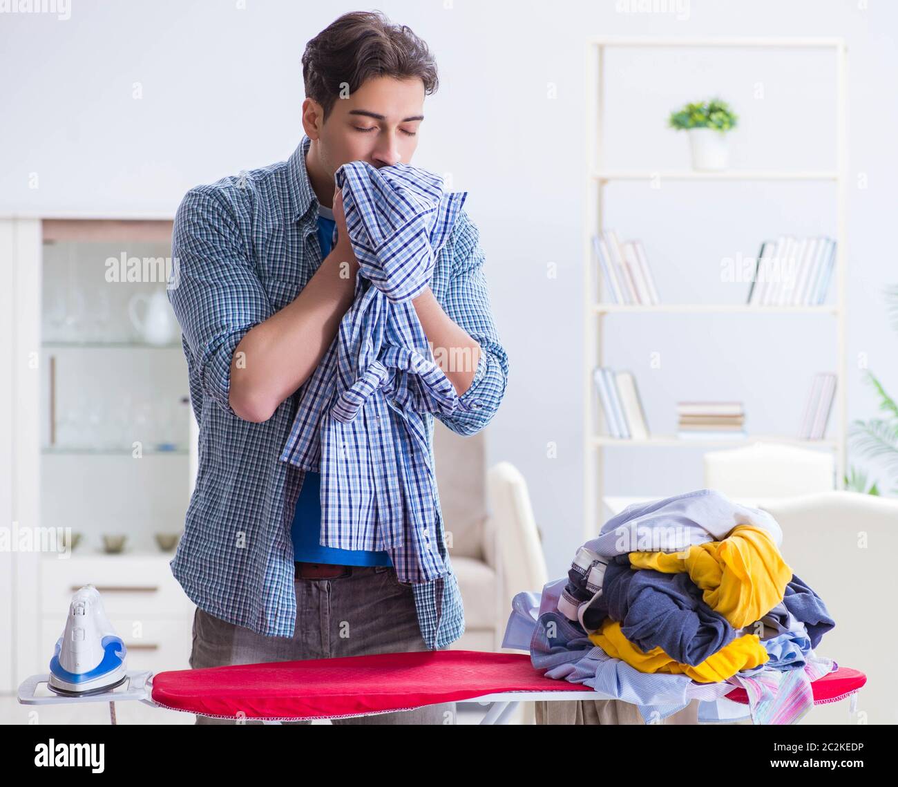The young man husband doing clothing ironing at home Stock Photo - Alamy