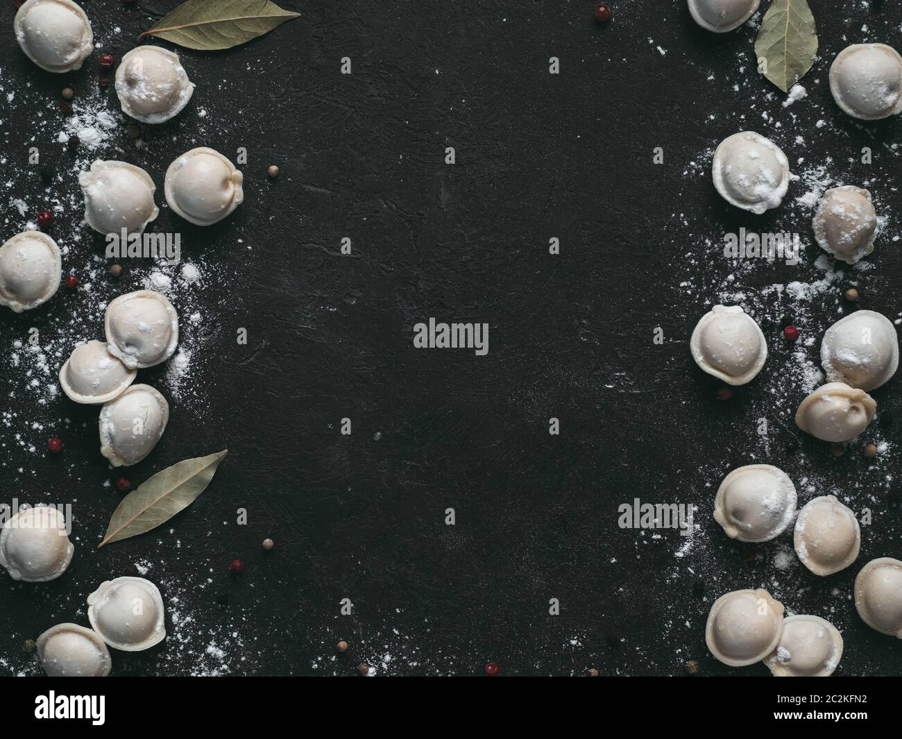 Pattern of frozen uncooked russian pelmeni with peppercorns and bay ...