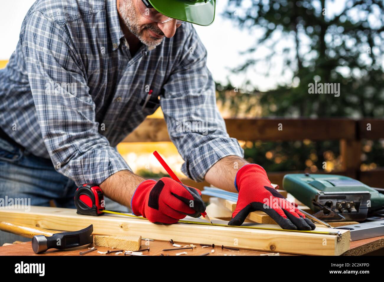 Adult carpenter craftsman wearing helmet and protective gloves, with ...