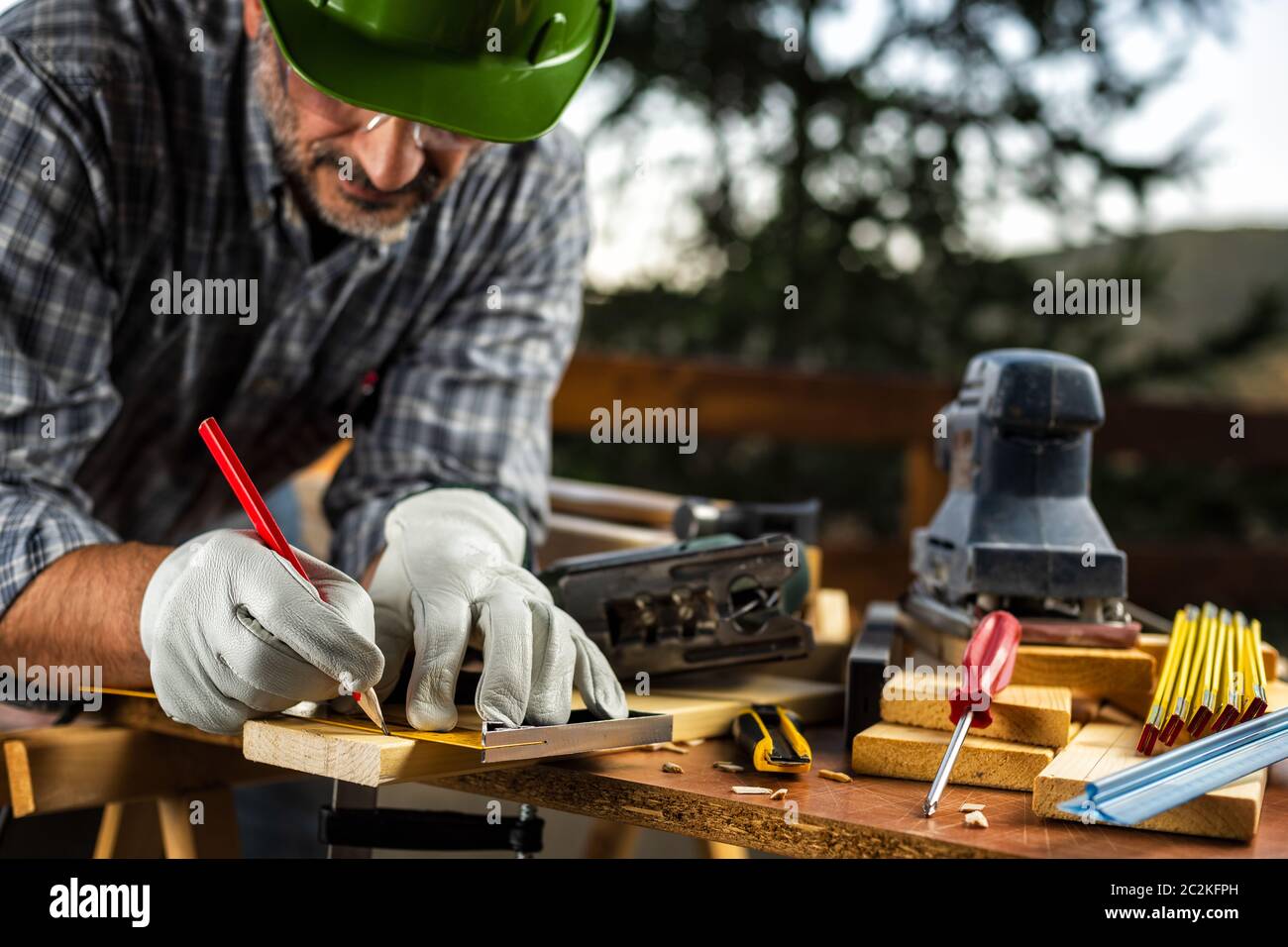 Adult carpenter craftsman wearing helmet and protective leather gloves ...