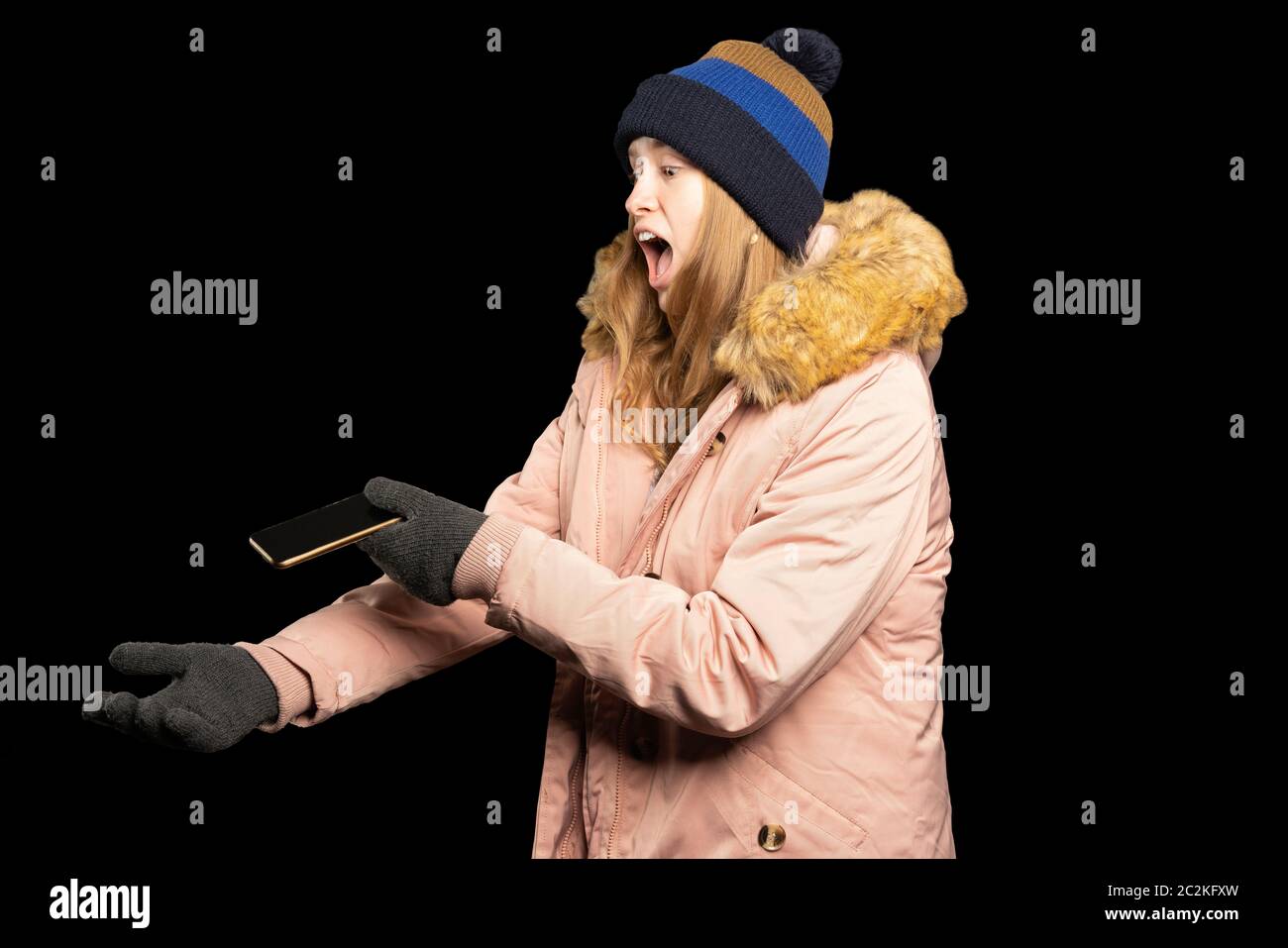 a frightened-looking woman lets her cell phone fall out of her hand ...