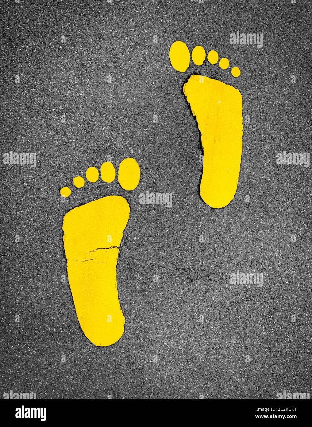 Yellow footprint painted on asphalt road. Walkway lane traffic sign ...