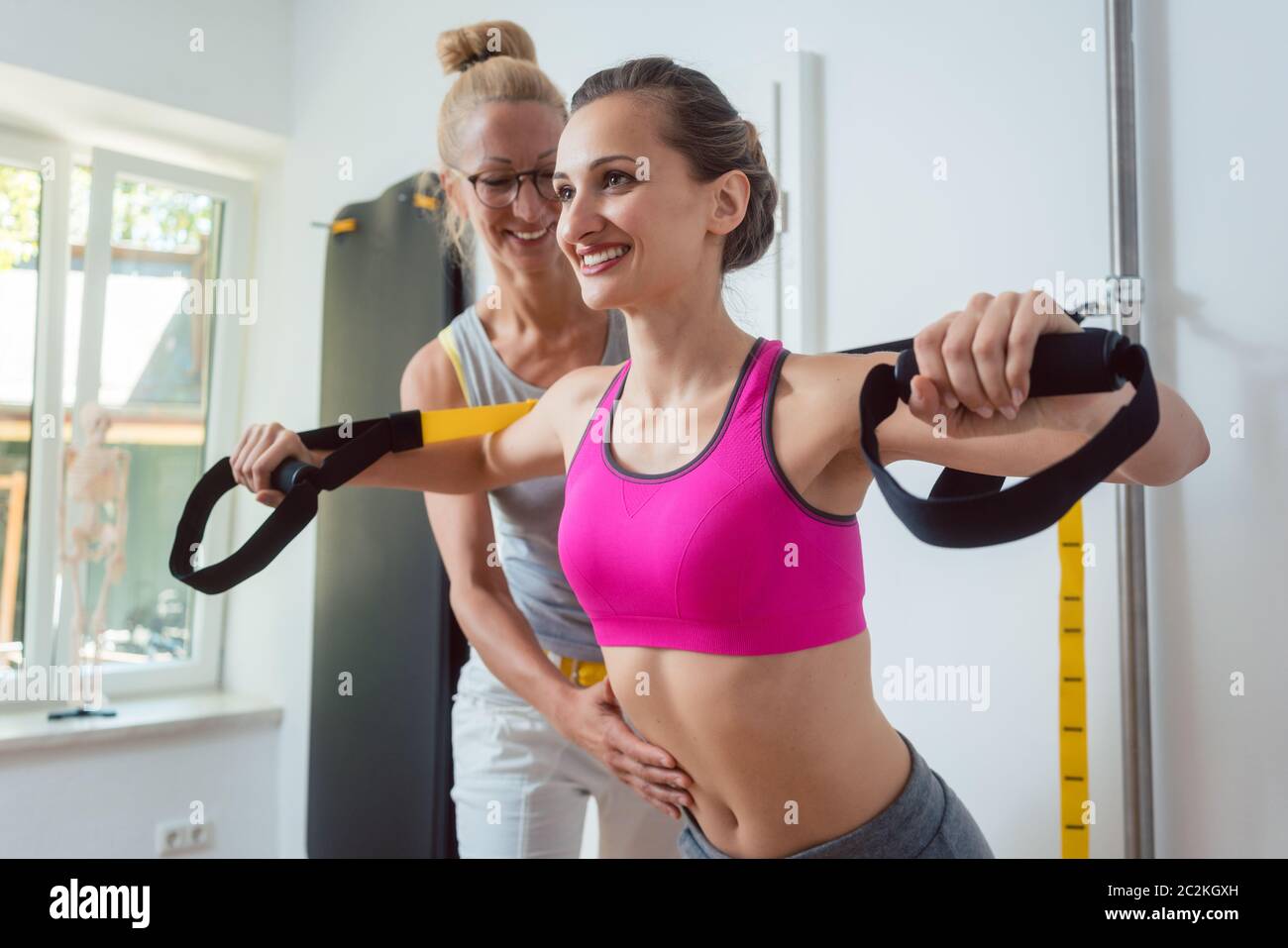 Woman using sling trainer during physical therapy Stock Photo - Alamy