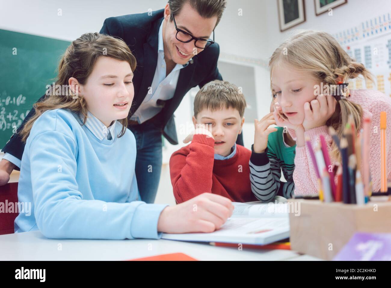 Teacher and students working together in a group or team session being ...