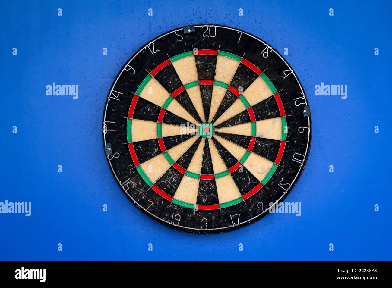 A dartboard in front of a blue background Stock Photo - Alamy