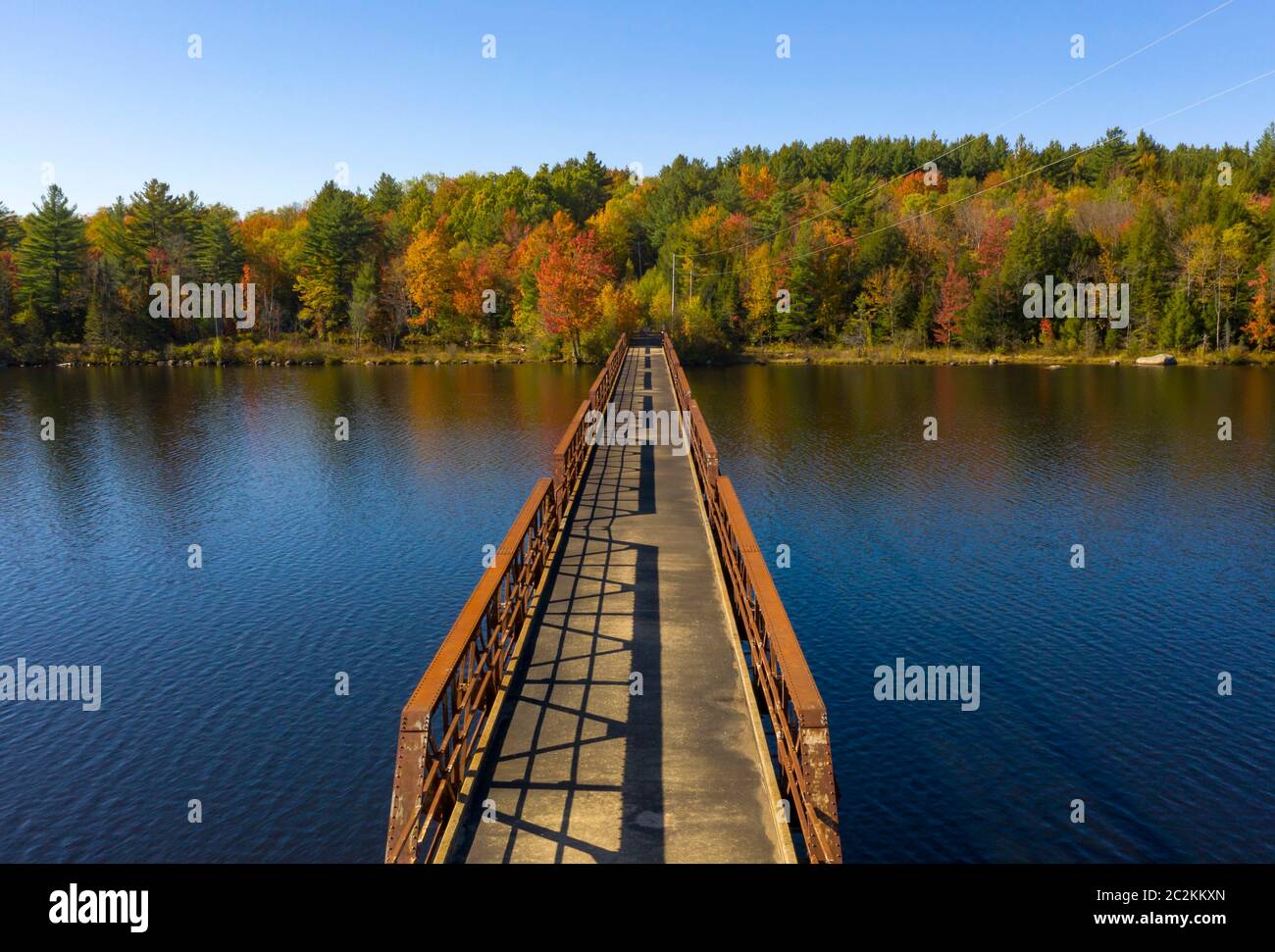 Fall color has begun to appear in the trees around a like in the ...
