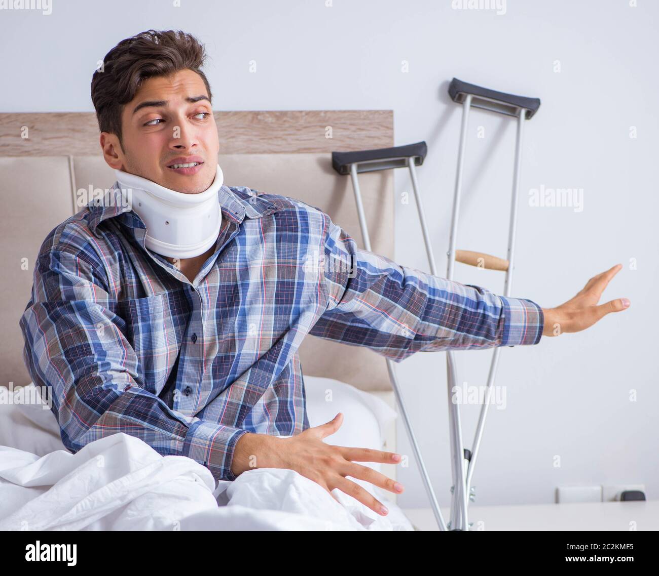The injured man in bed at home with crutches Stock Photo - Alamy