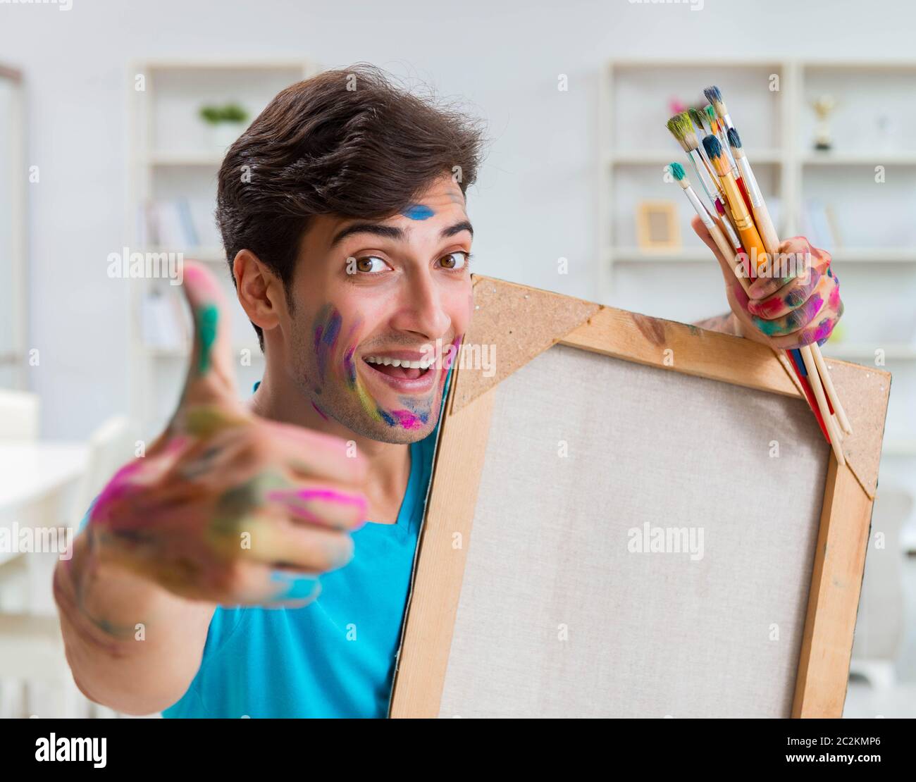 The young funny artist working on new painting in his studio Stock ...