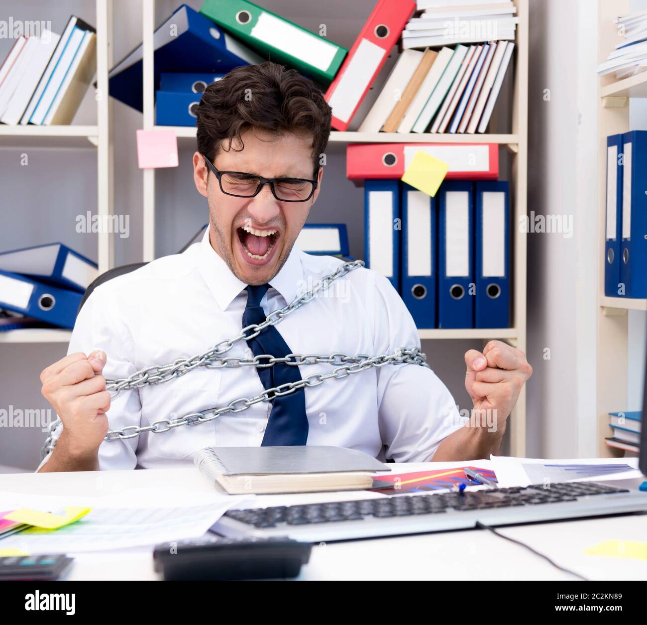 The employee attached and chained to his desk with chain Stock Photo ...
