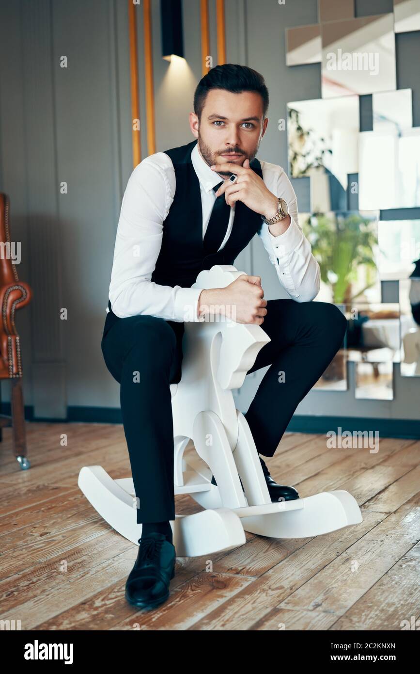 Adult man ride wooden rocking horse Stock Photo - Alamy