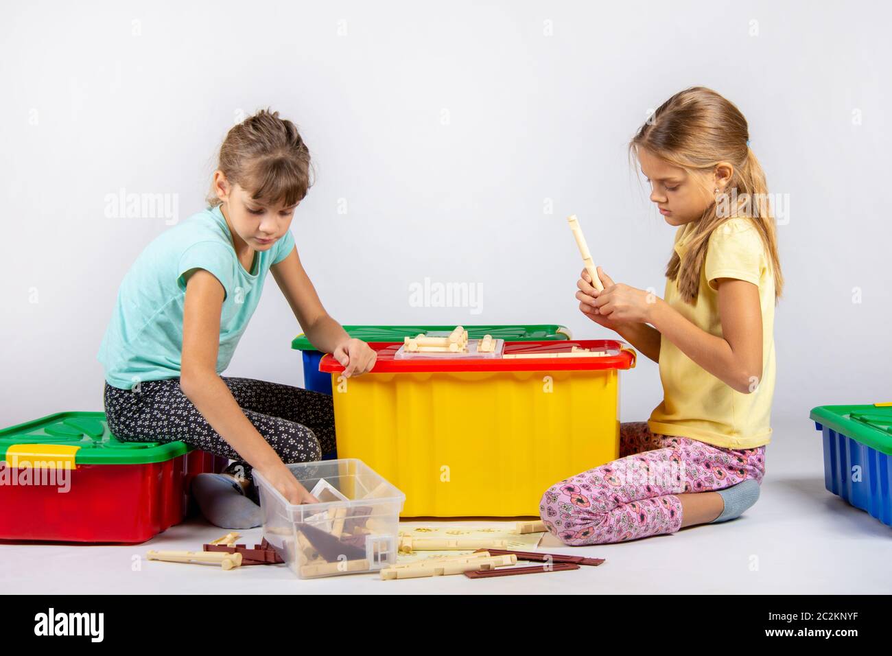 Two girls collect a house from the designer on a large plastic box ...