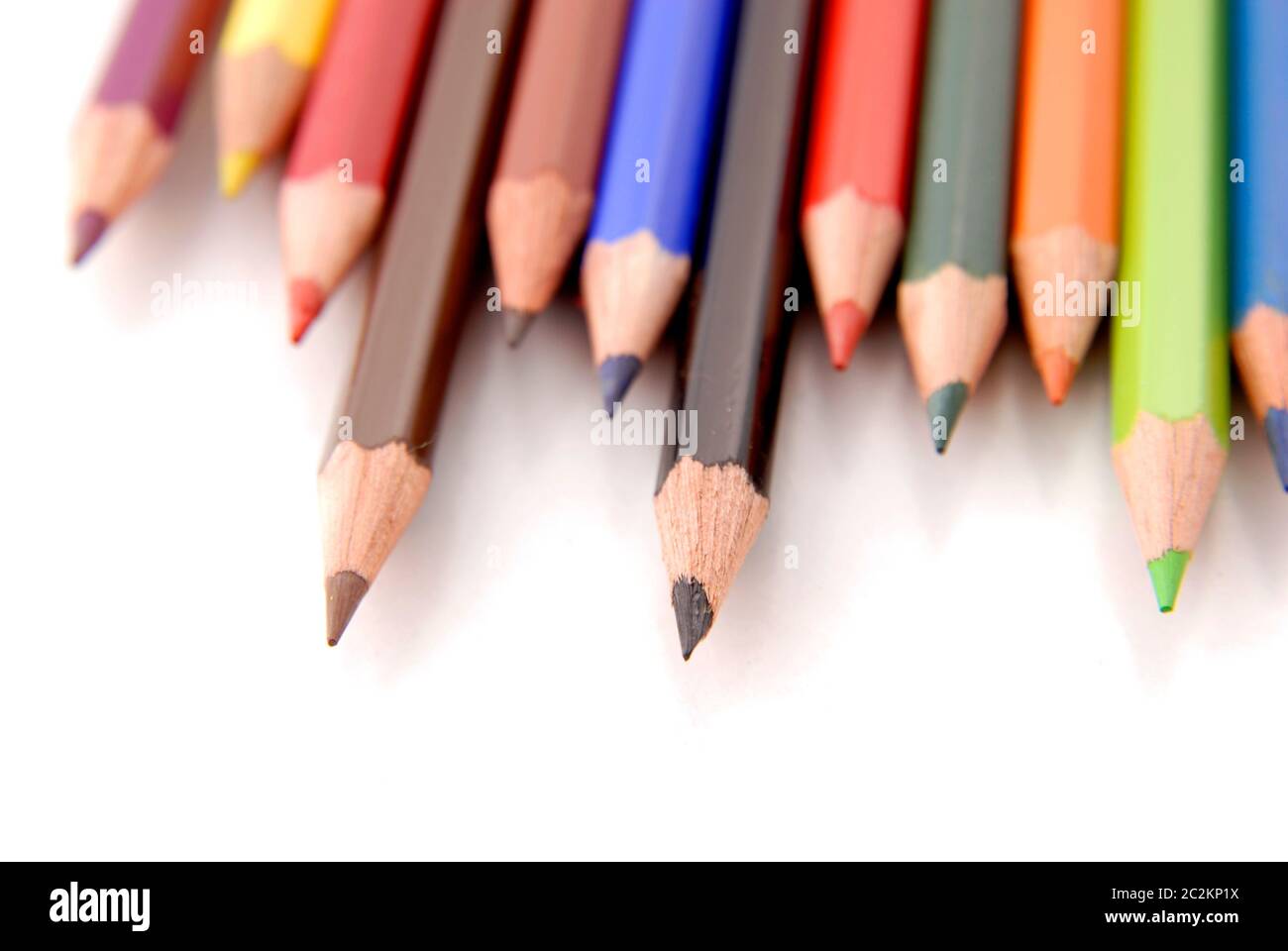 color pencils aligned and isolated on white, focus on the midle one ...