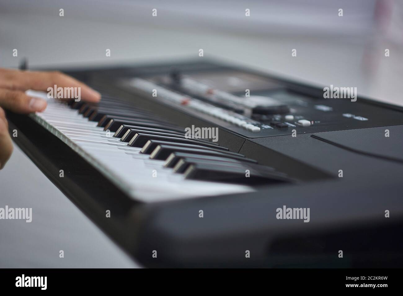 Hand of a musician pressing the keys of an electronic keyboard while ...