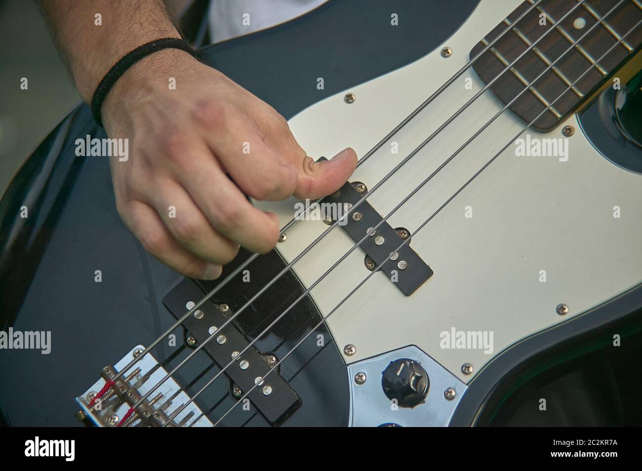 Detail of a bass player who plays his eacoustica bass at a live rock ...