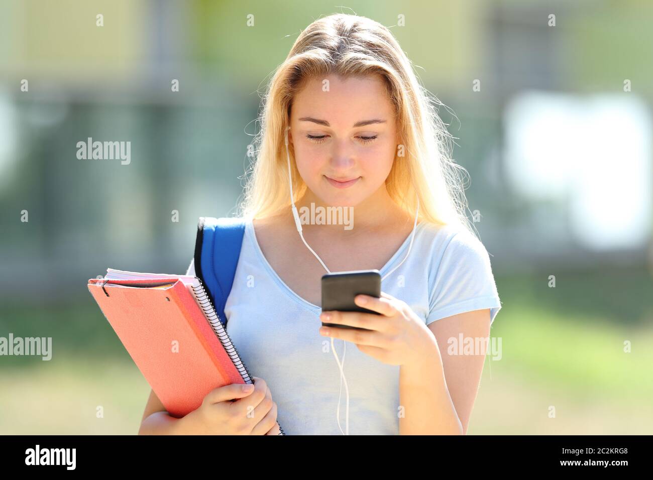 Front view portrait of serious student girl listening to music wearing ...