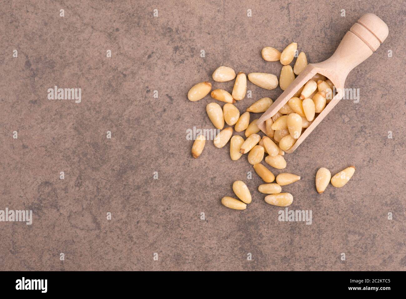 Pine nuts on a brown textured background Stock Photo - Alamy