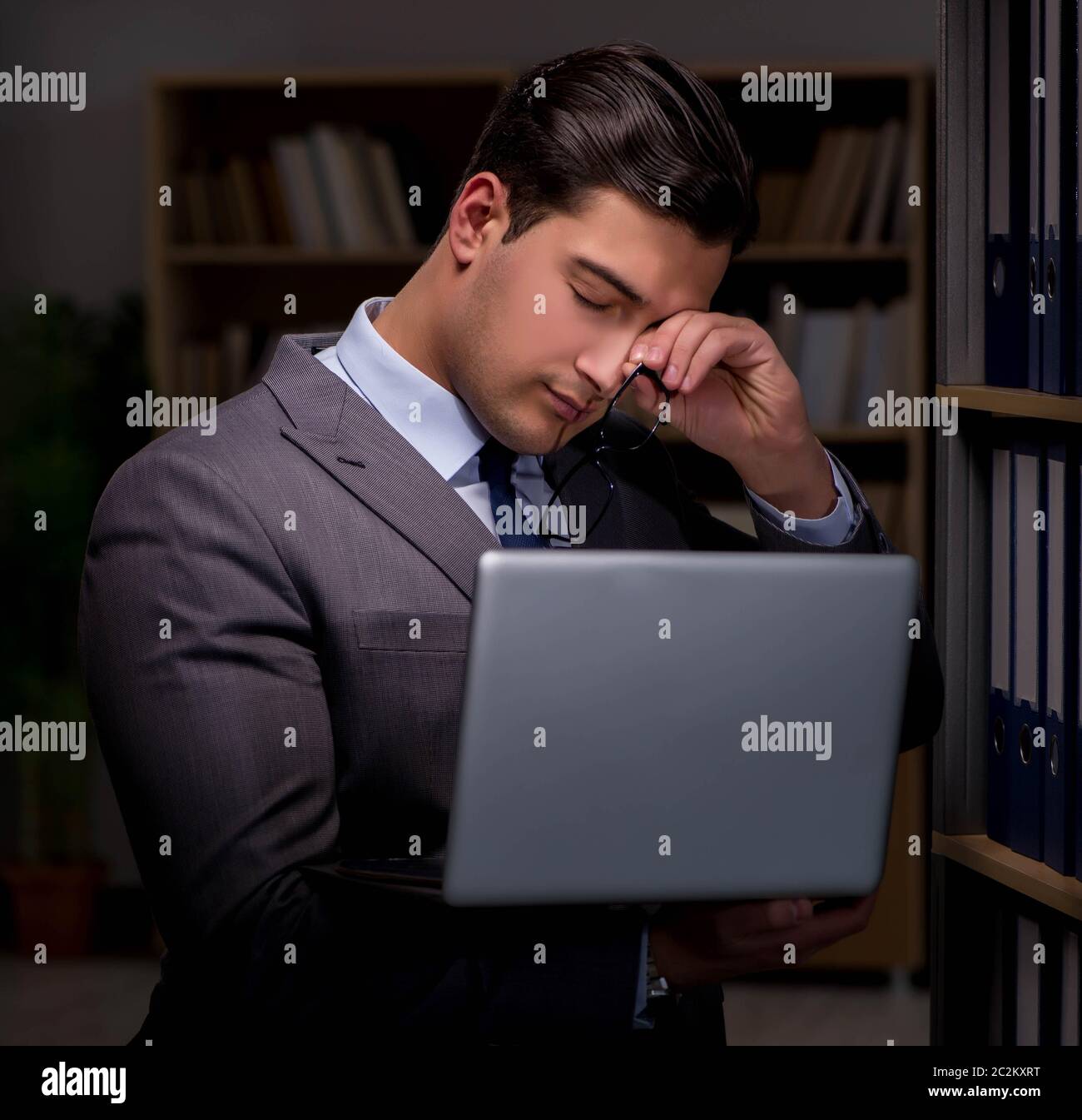 Businessman almost falling asleep working late hours in the office ...