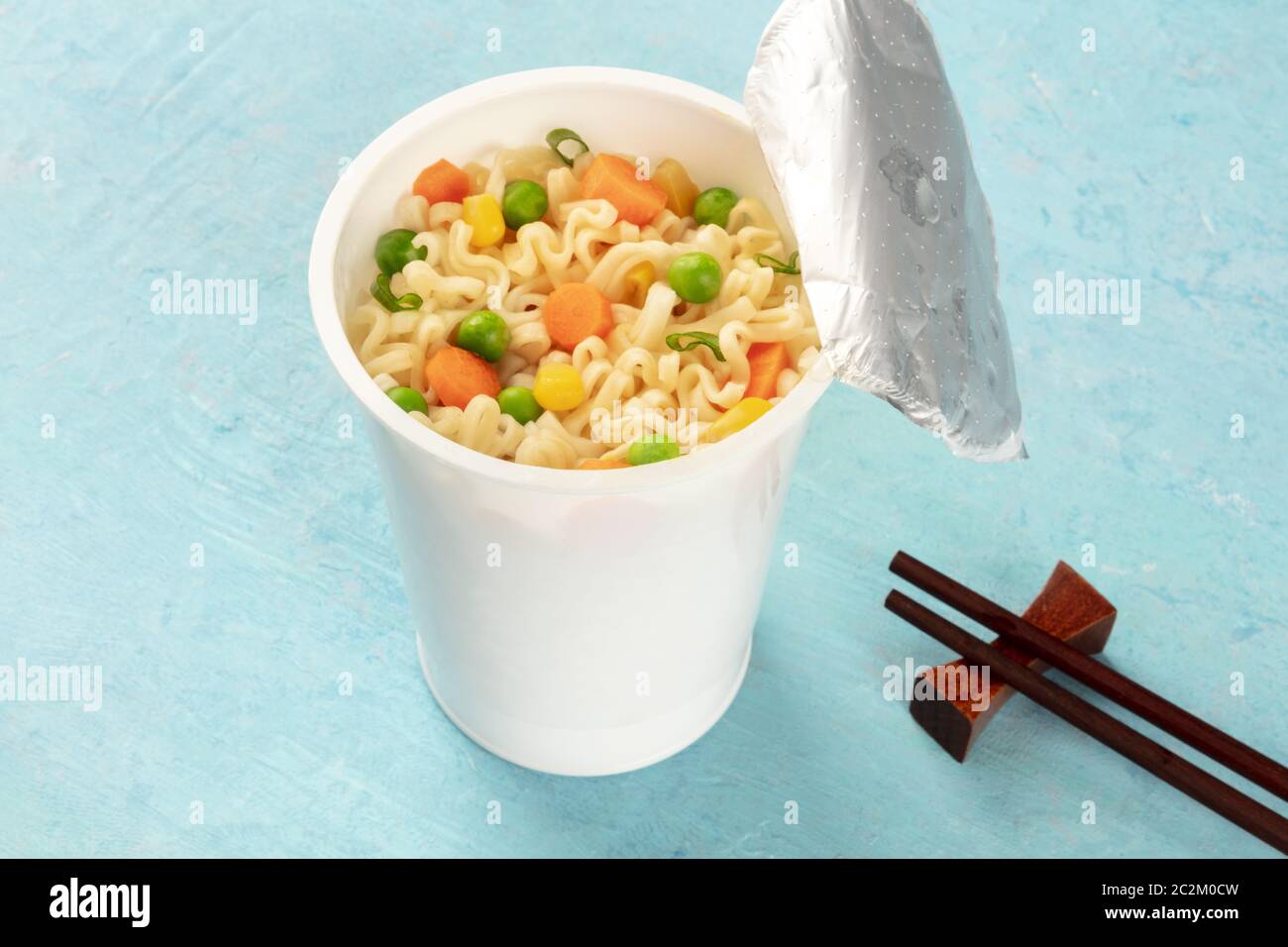 Ramen noodles cup close-up, instant noodles in a plastic cup on a blue ...