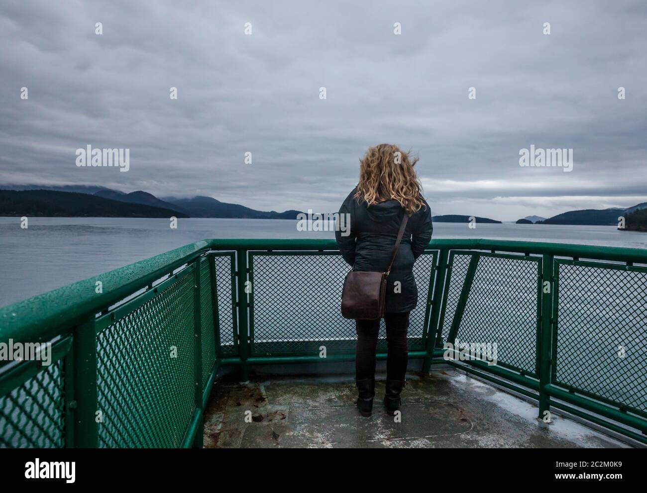 A woman stands on the observation deck on a Washington State Ferry as ...