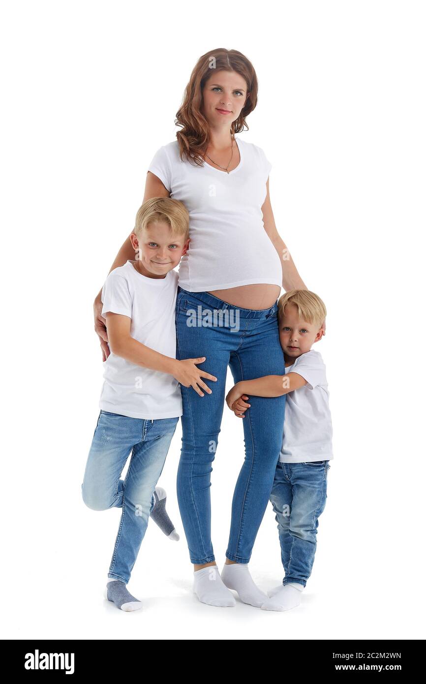 Friendly family. Two little sons are smiling and embracing pregnant ...