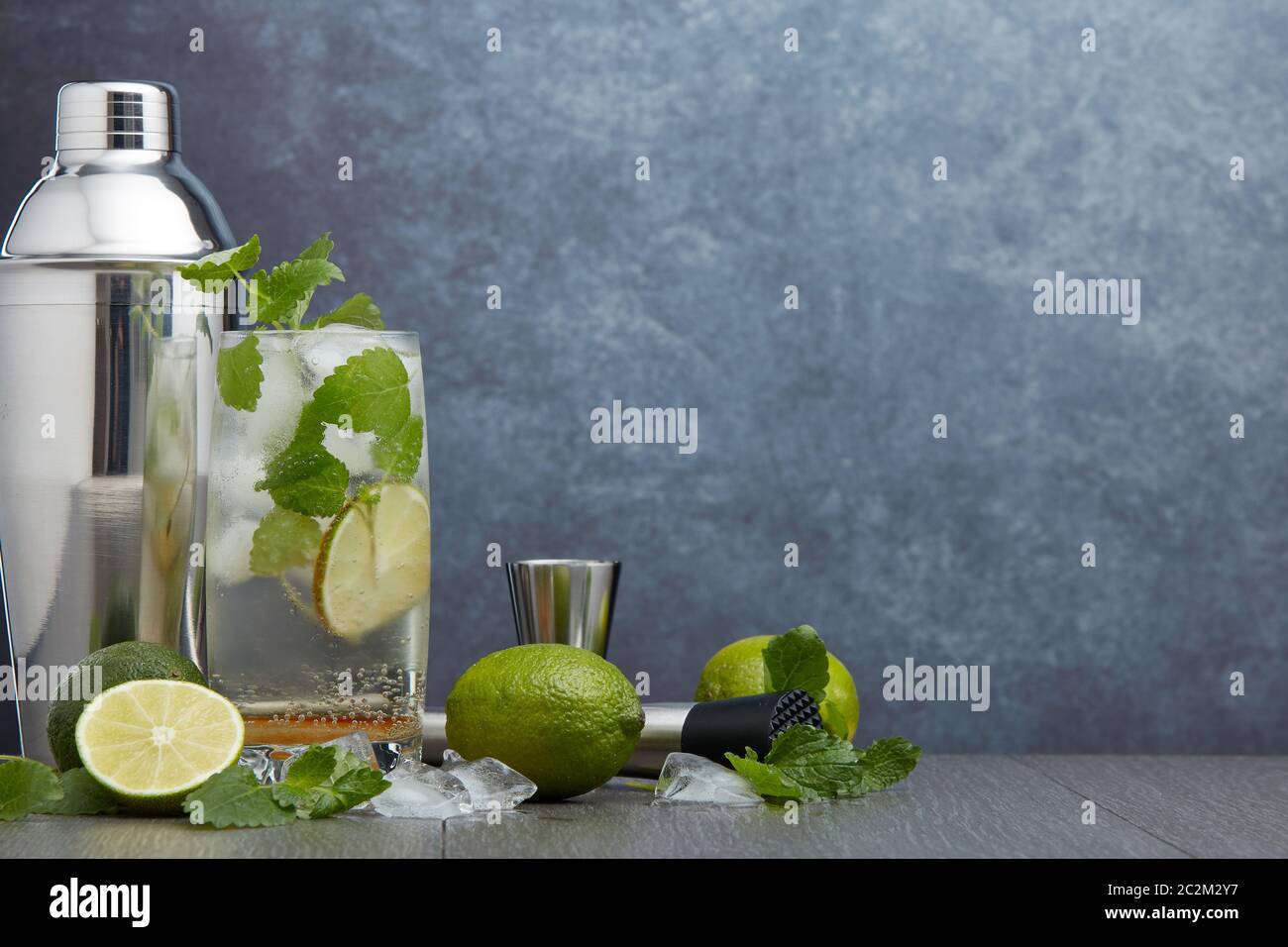 Set of bar tools: cocktail shaker, muddler, jigger, cocktail with ice ...