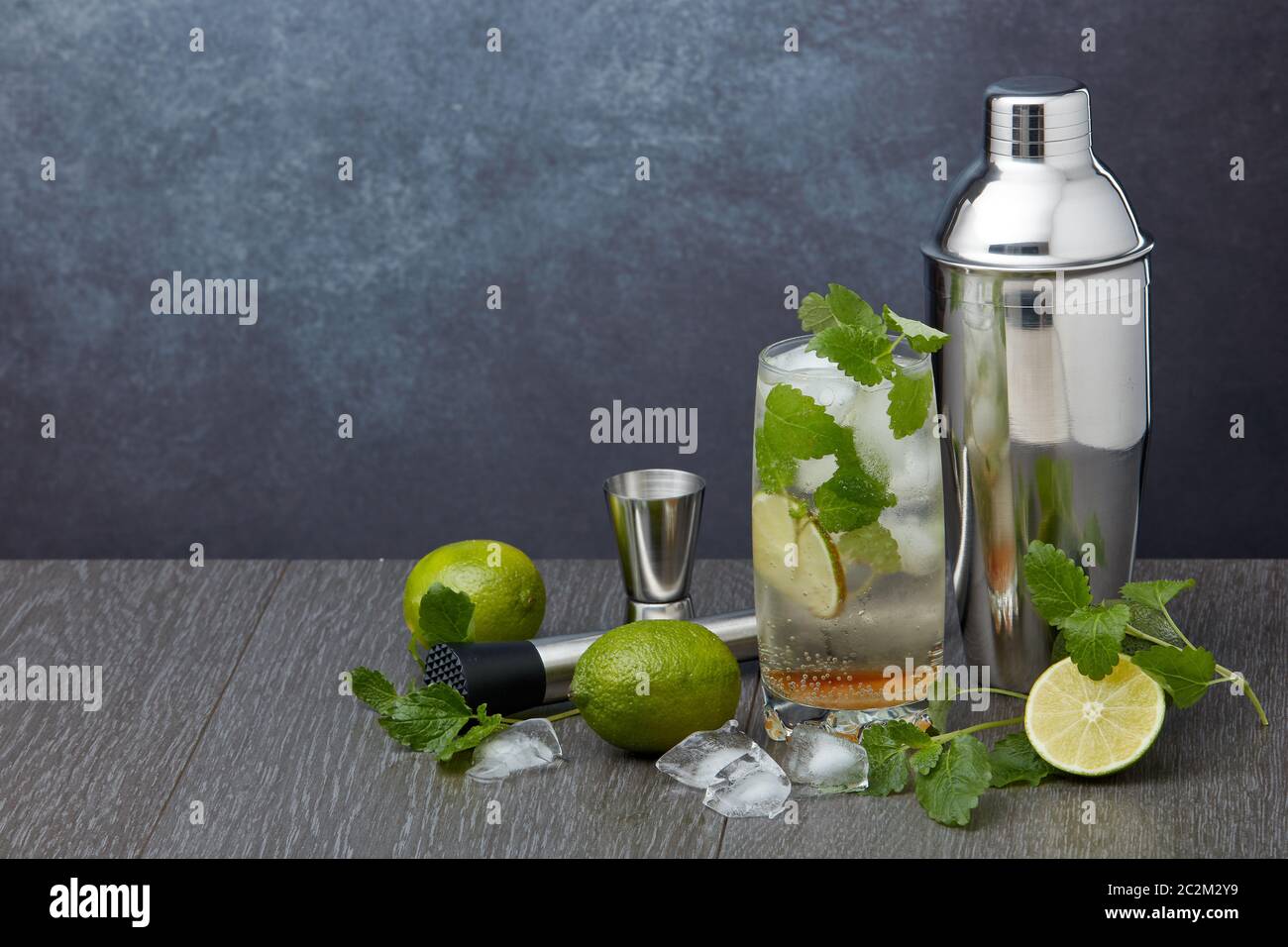 Set of bar tools: cocktail shaker, muddler, jigger, cocktail with ice ...