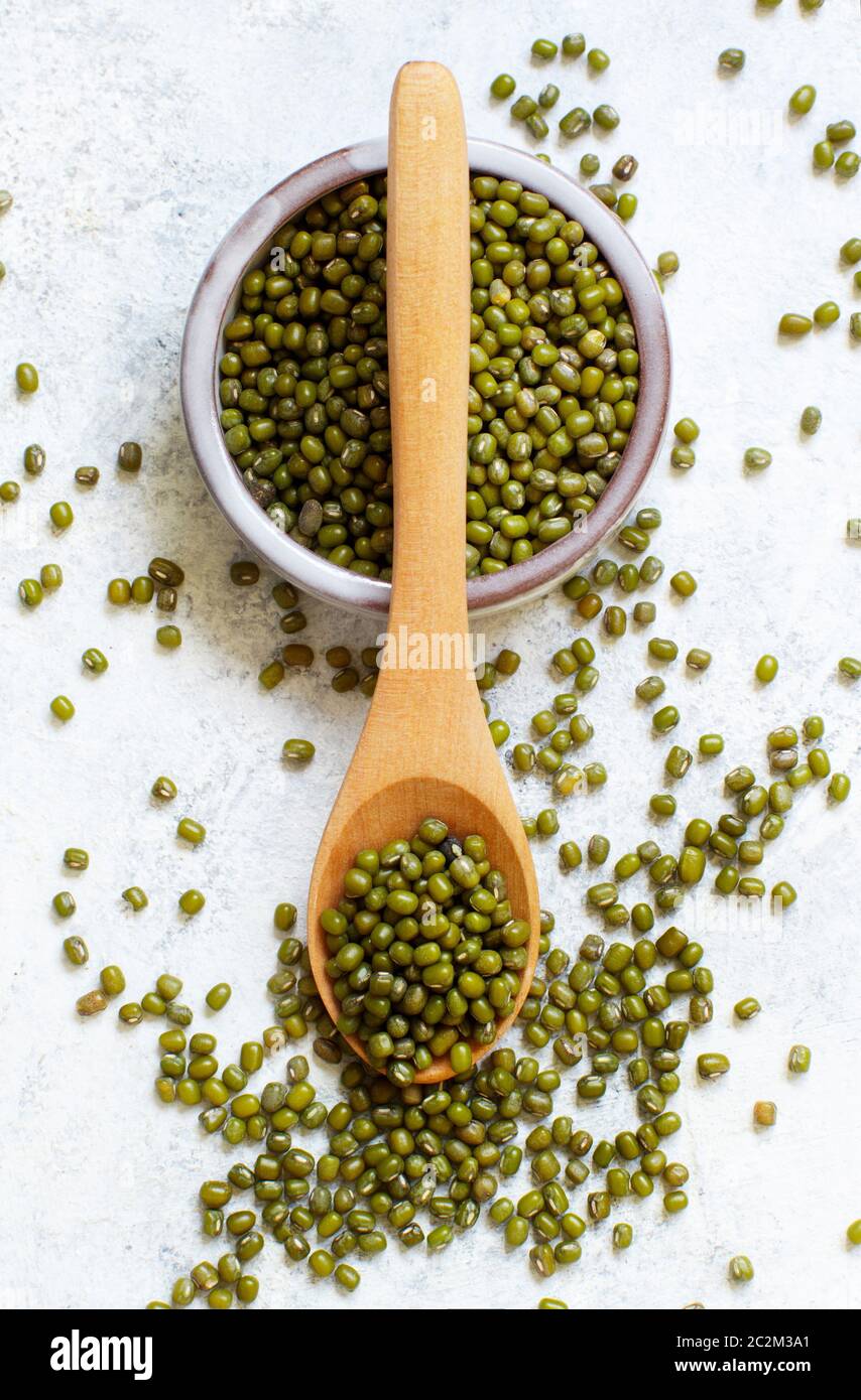 Dried mung beans in a bowl with a wooden spoon top view Stock Photo - Alamy