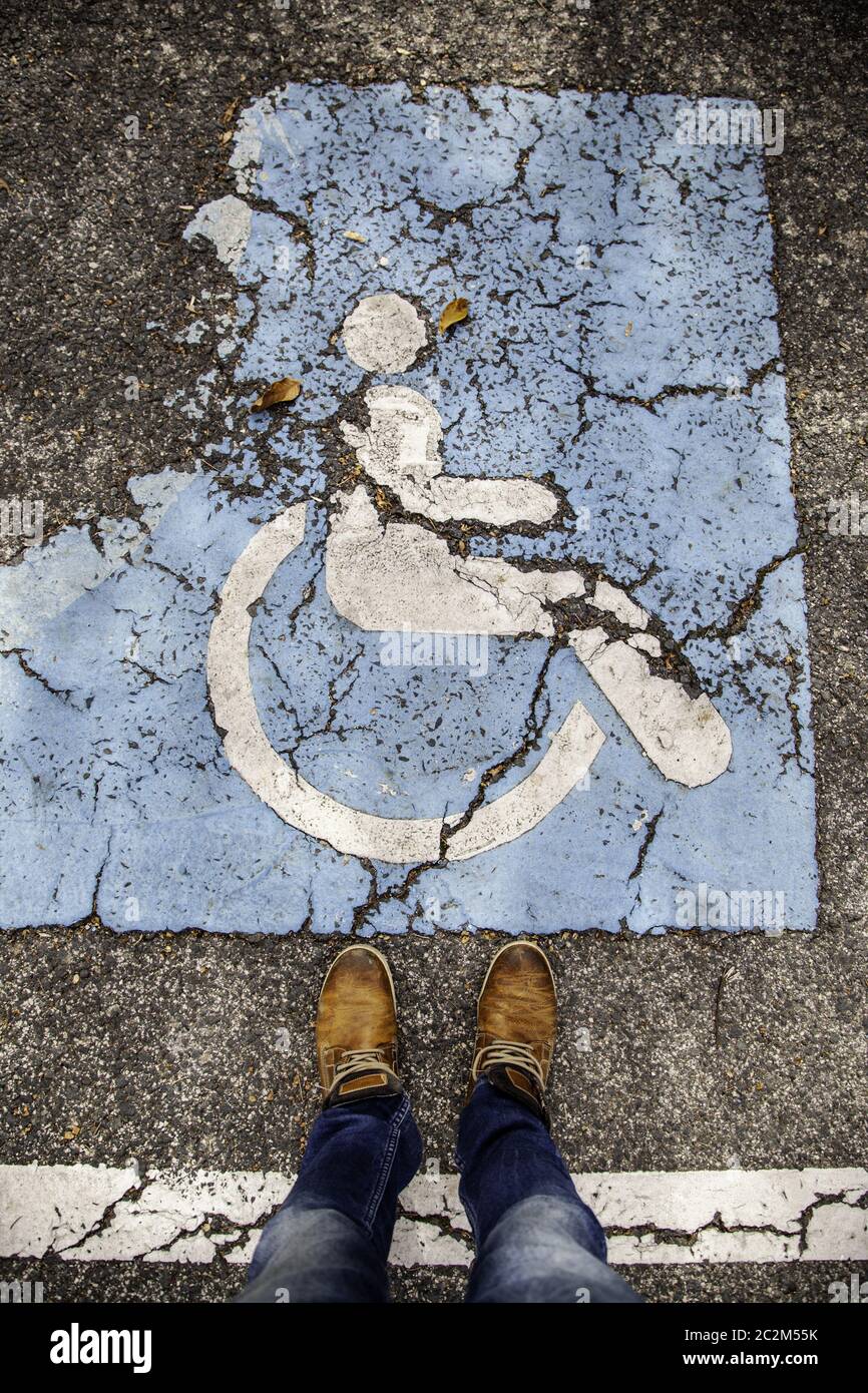 Disabled sign on the asphalt, detail of social integration, facilities ...