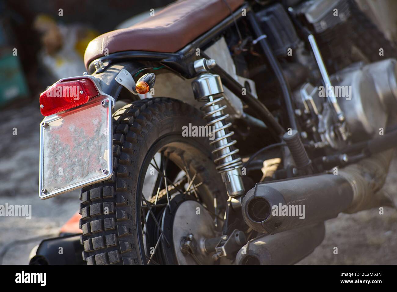 Back of a vintage motorcycle with the red light in the middle and other ...