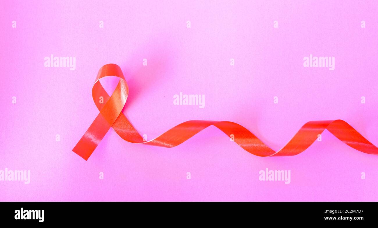 Red Ribbon Support HIV, AIDS on pink background and copy space for use ...