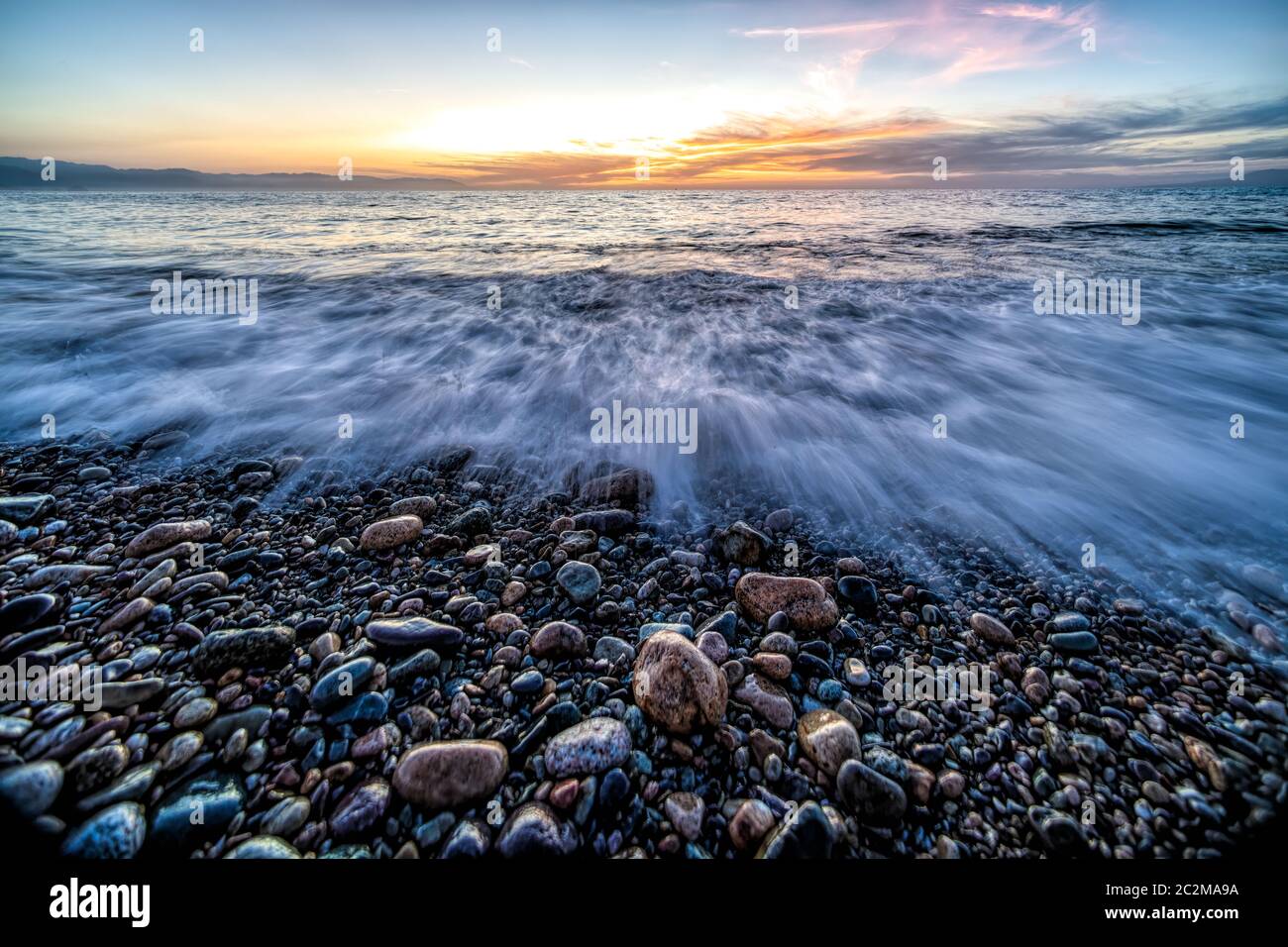 A Low Angle Seascape of Beach Rocks as Ocean Water Rushes to the Sea ...