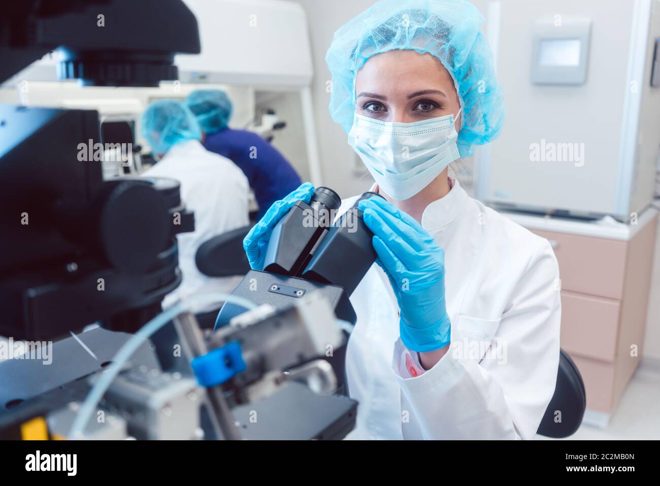 Woman doctor working on manipulator fertilizing human eggs in fertility ...