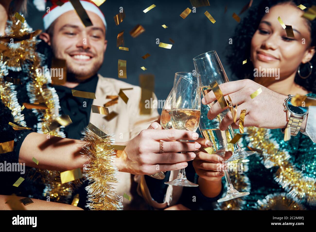 Multiethnic friends toasting with champagne celebrating Christmas party ...