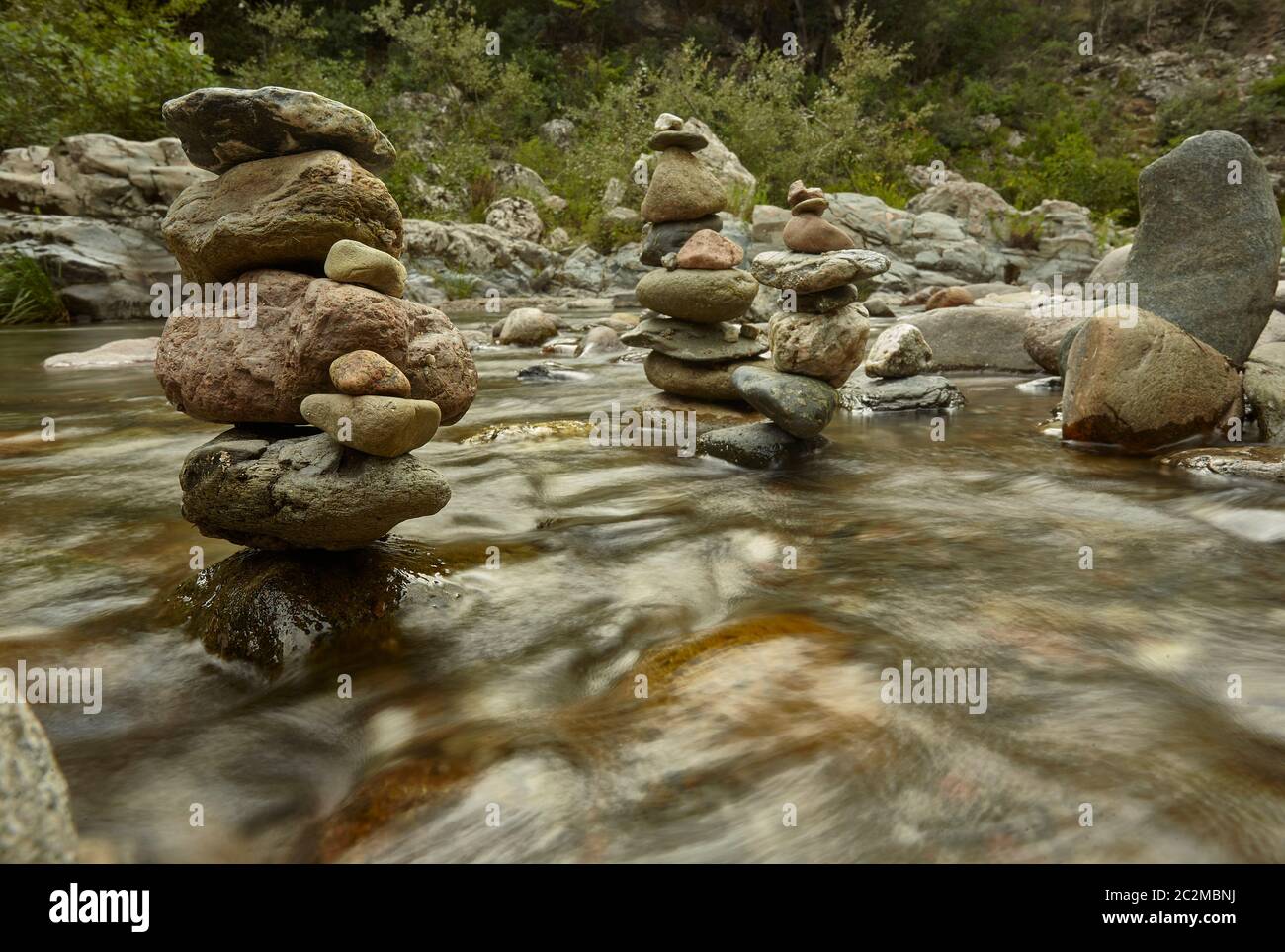 Piles of zen rocks in the middle of the mountain stream with the ...