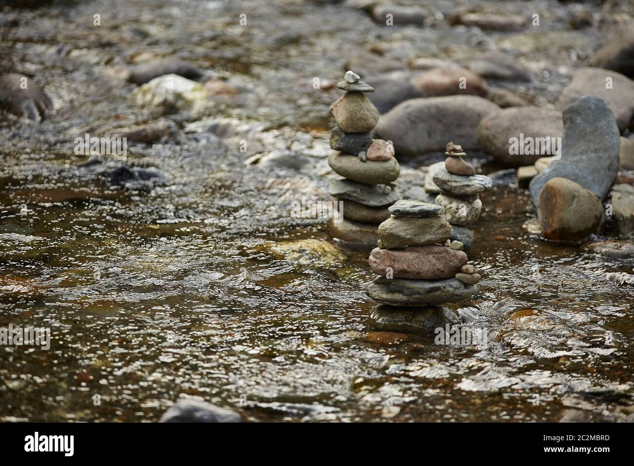 Pile of rocks in the middle of a stream with transparent water that ...