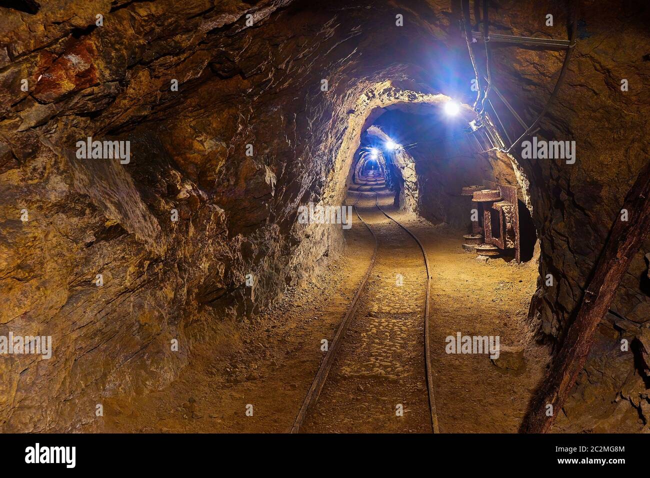Mining tunnel underground with lights and rails Stock Photo - Alamy