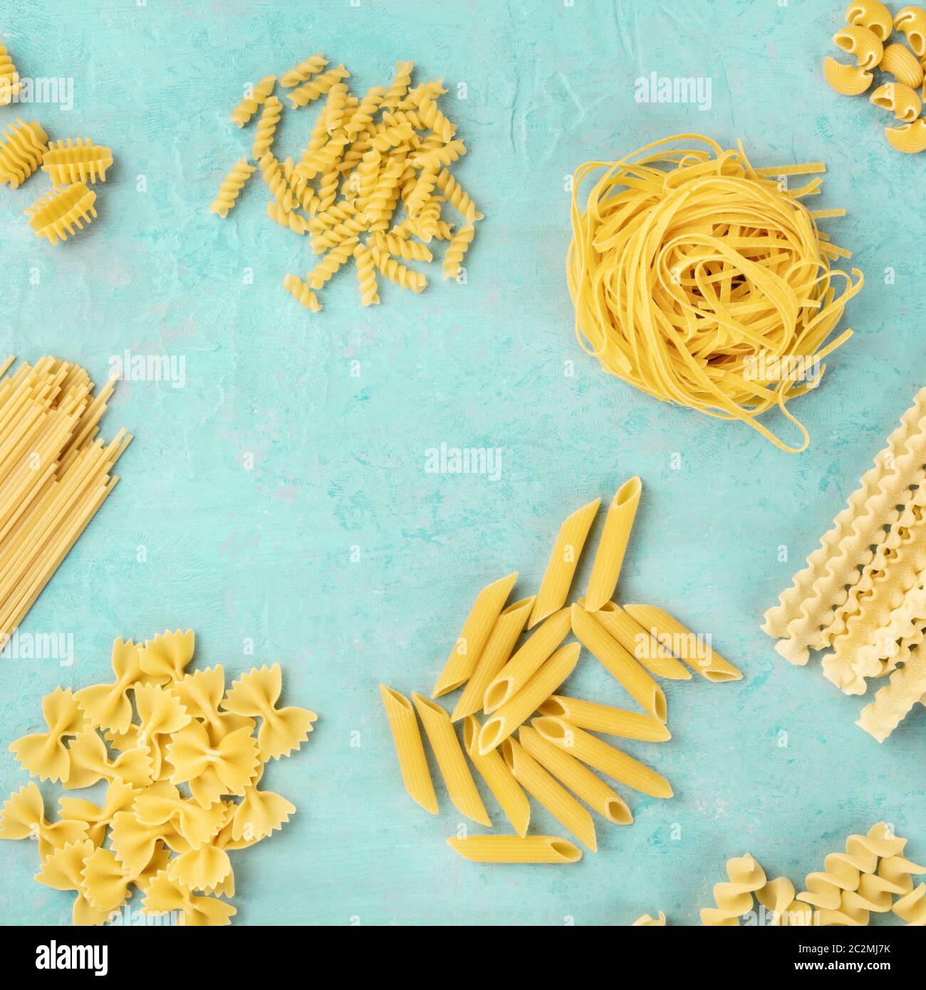 Italian pasta variety, square overhead flat lay shot on a teal blue ...