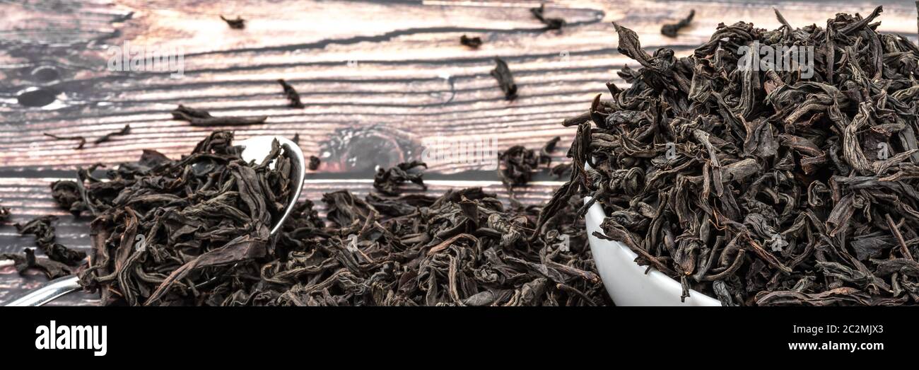 Dried tea is poured into a ceramic cup on a wooden plank table Stock ...