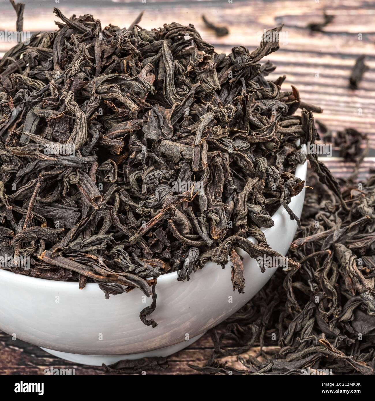 Dried tea is poured into a ceramic cup on a wooden plank table Stock ...