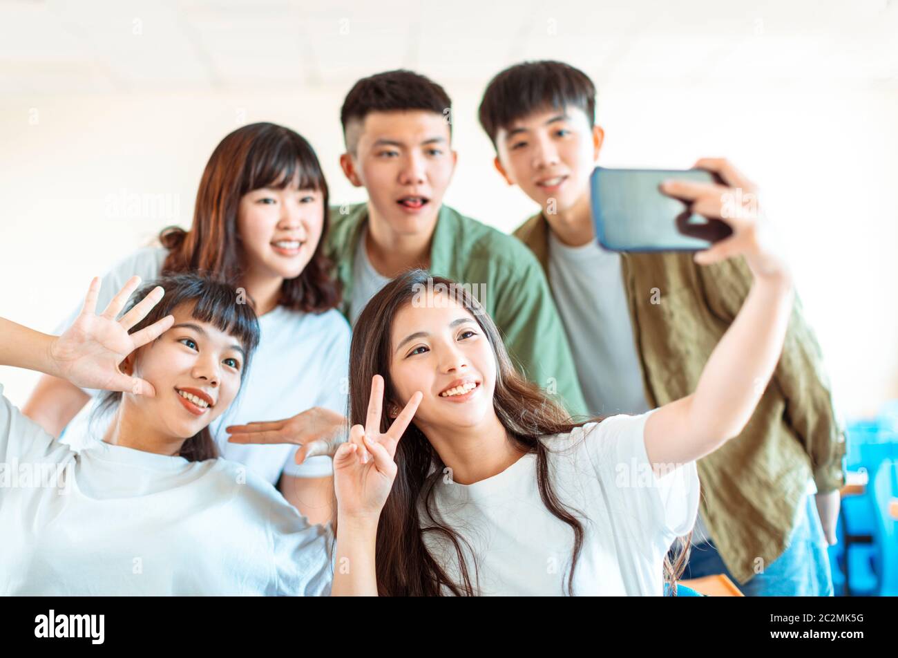 happy young group of teenagers making fun selfie in classroom Stock ...