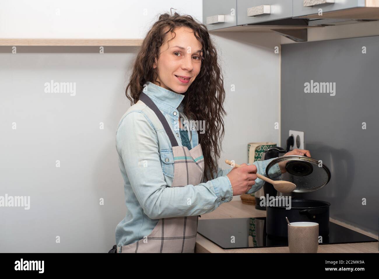 a young woman with long hair is in the kitchen Stock Photo - Alamy