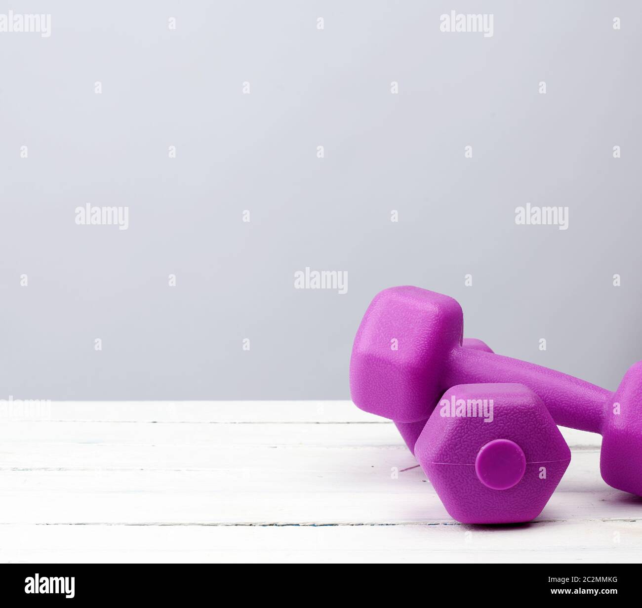 pair of purple plastic dumbbell for sports, white background. Fitness ...